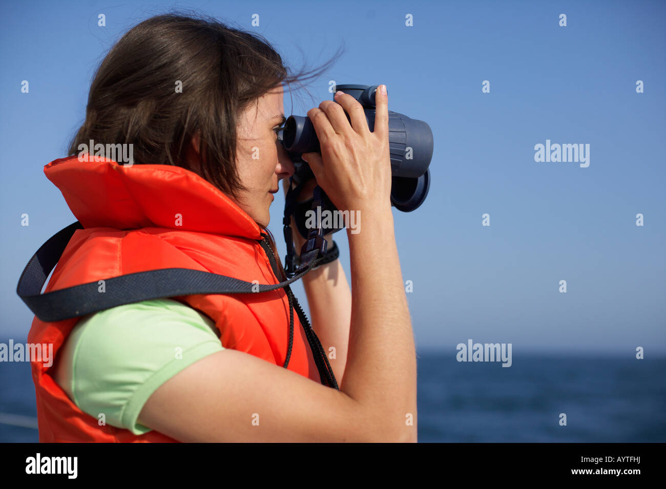 Woman looking through a spyglass, side view Stock Photo - Alamy