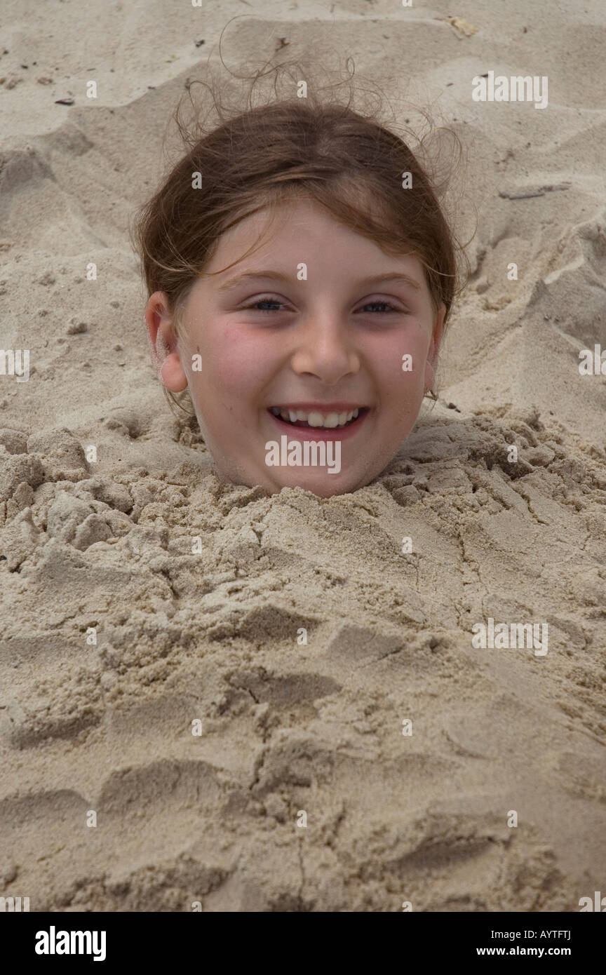Young girl buried in sand Stock Photo - Alamy