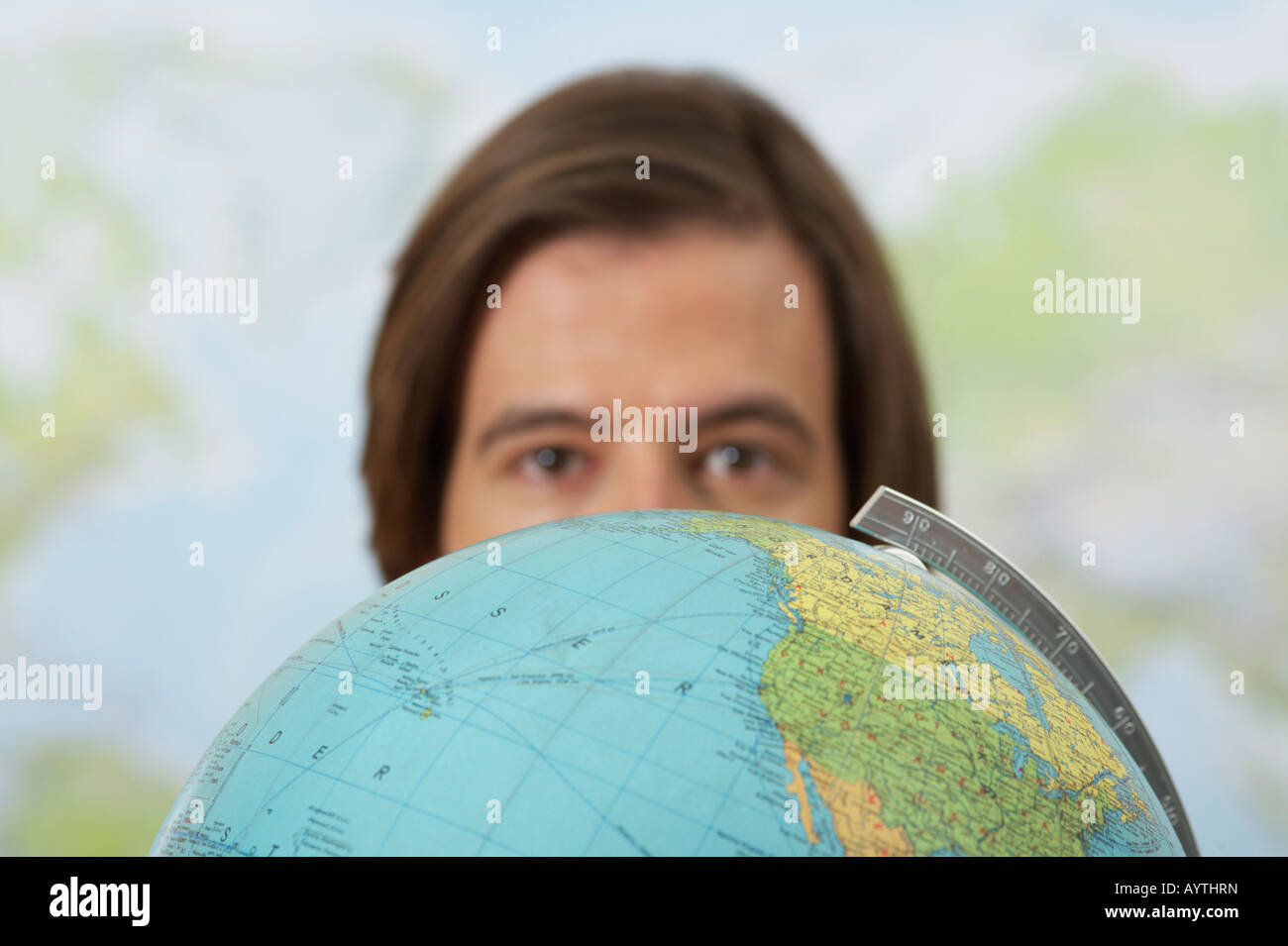 A man in the middle of world map and globe Stock Photo - Alamy