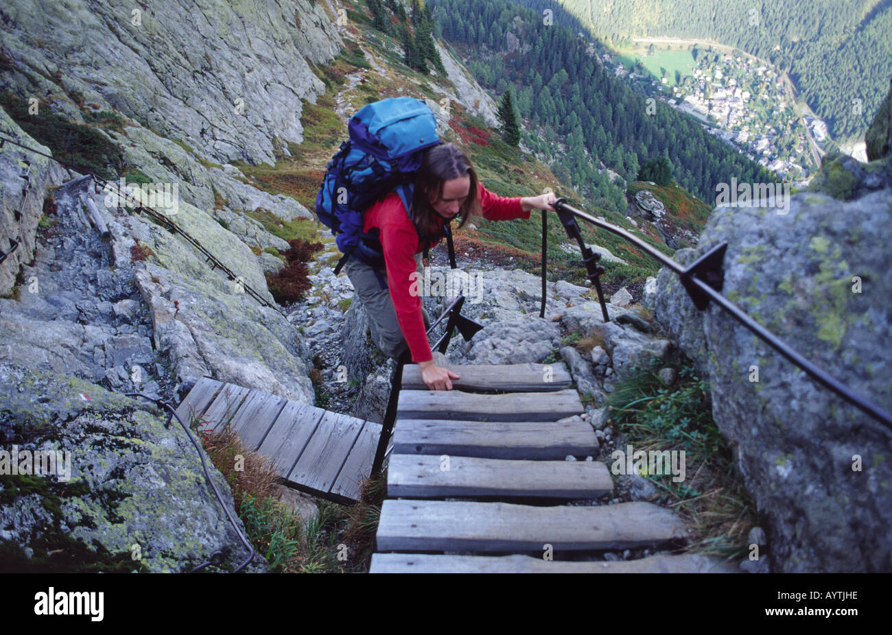 Trekker climbing ladders above Argentiere on the Tour of Mont Blanc ...