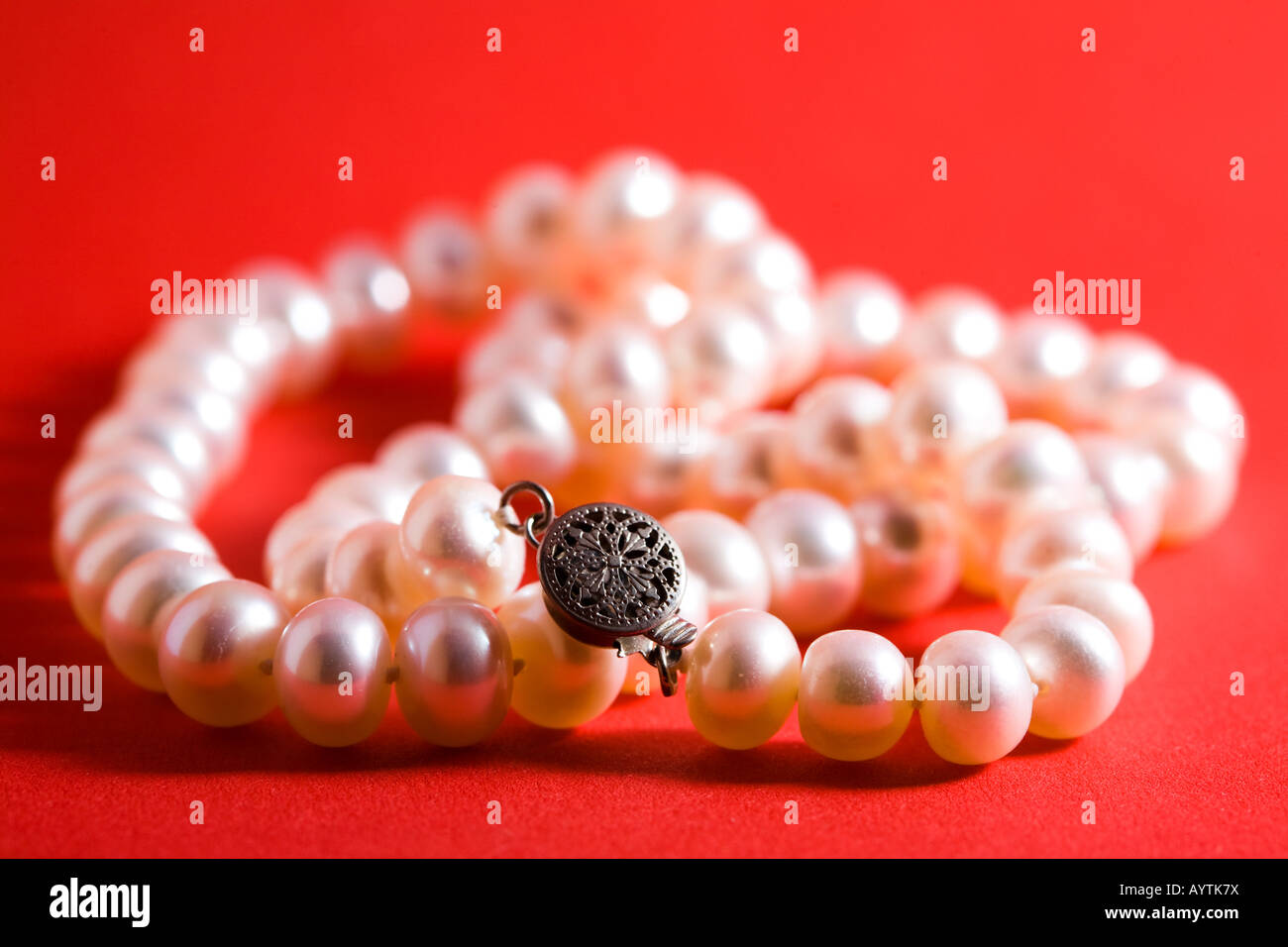 Pearl necklace on red background hi-res stock photography and images ...