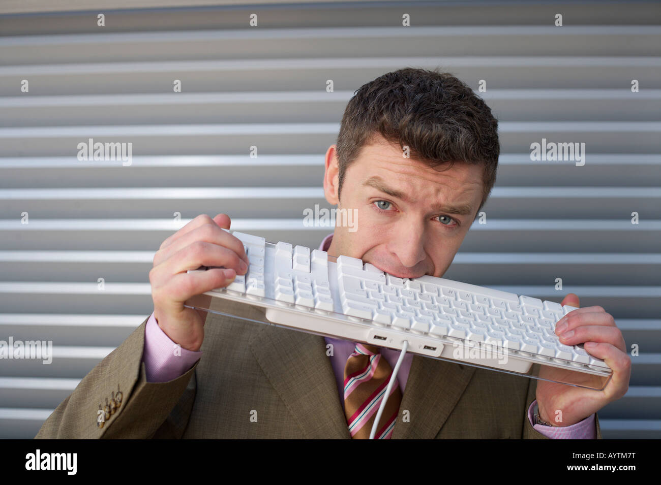 Businessman beating computer keyboard Stock Photo - Alamy