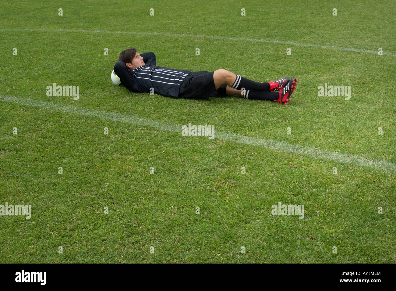 Relaxed referee lying on soccer field Stock Photo - Alamy