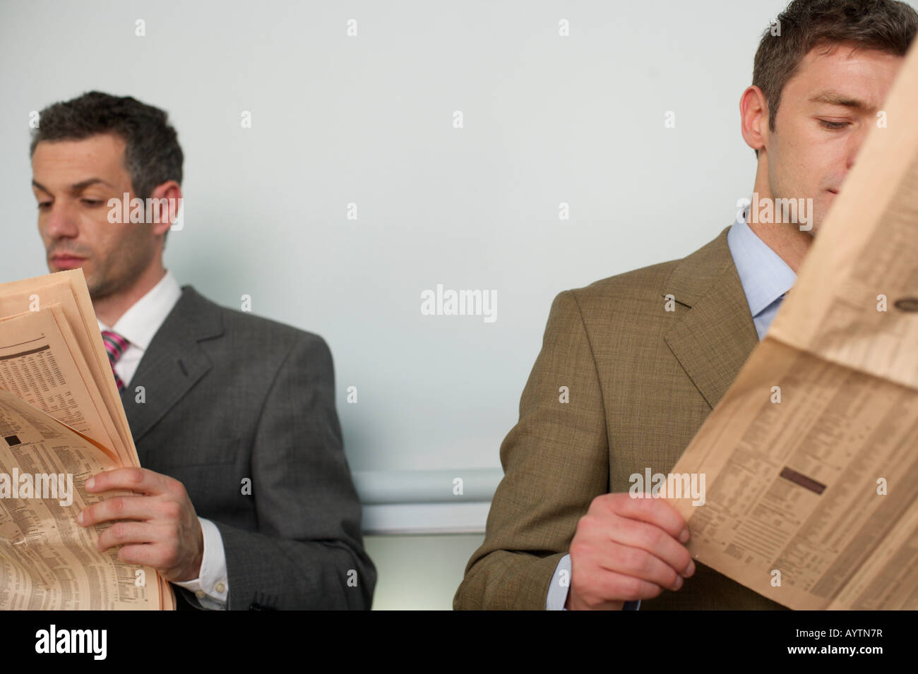 Two businessmen reading newspaper Stock Photo - Alamy