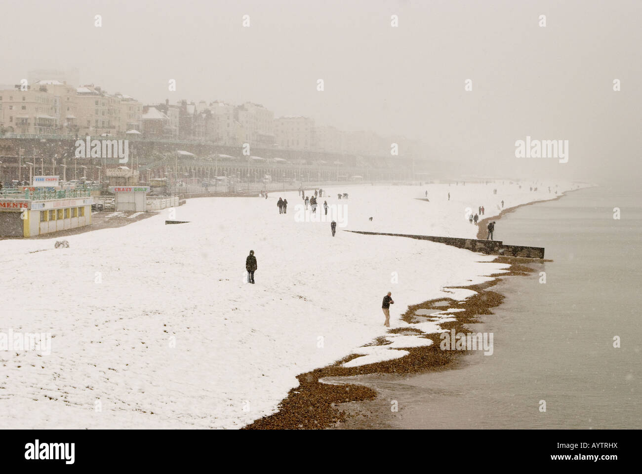 People enjoying snow on Brighton Beach in winter Stock Photo - Alamy