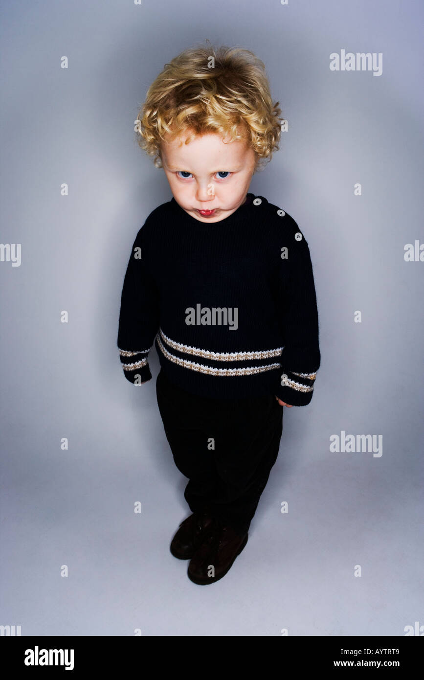 Portrait of young boy, angry, disappointed, sad and pouting expression ...