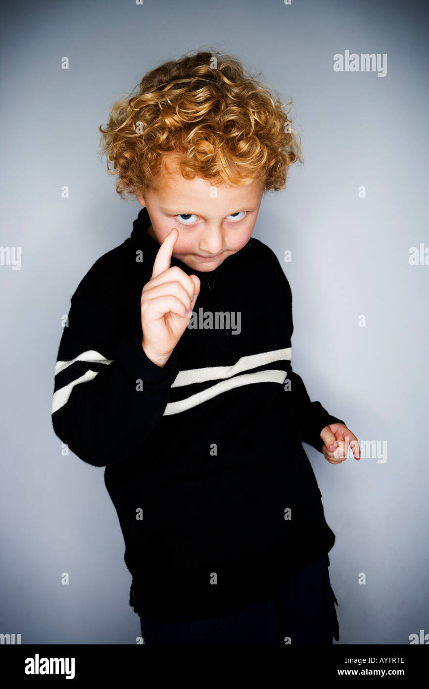 Cheeky portrait of young boy pointing fingers Stock Photo - Alamy