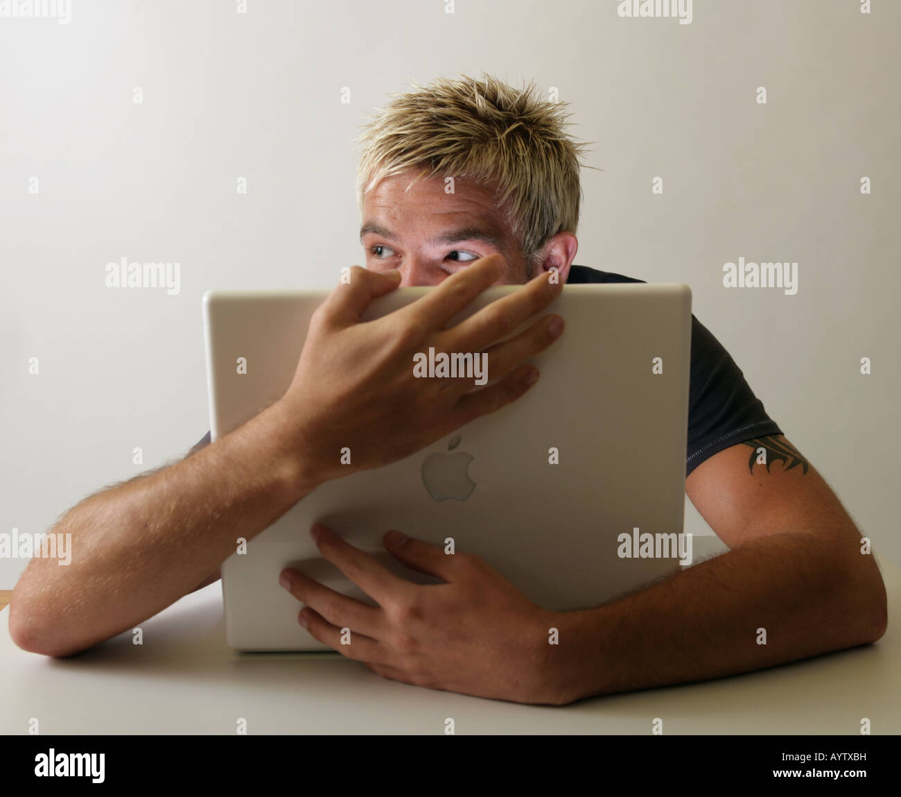 man holding onto a apple mac laptop Stock Photo - Alamy