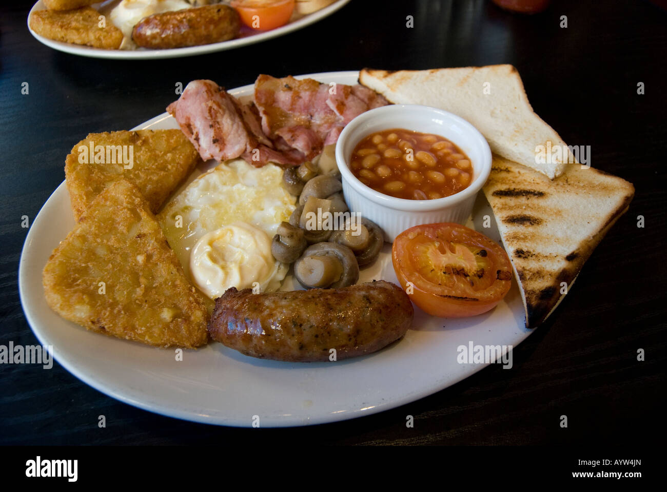 A traditional English Breakfast of toast,eggs,potatoes, tomato,baked ...