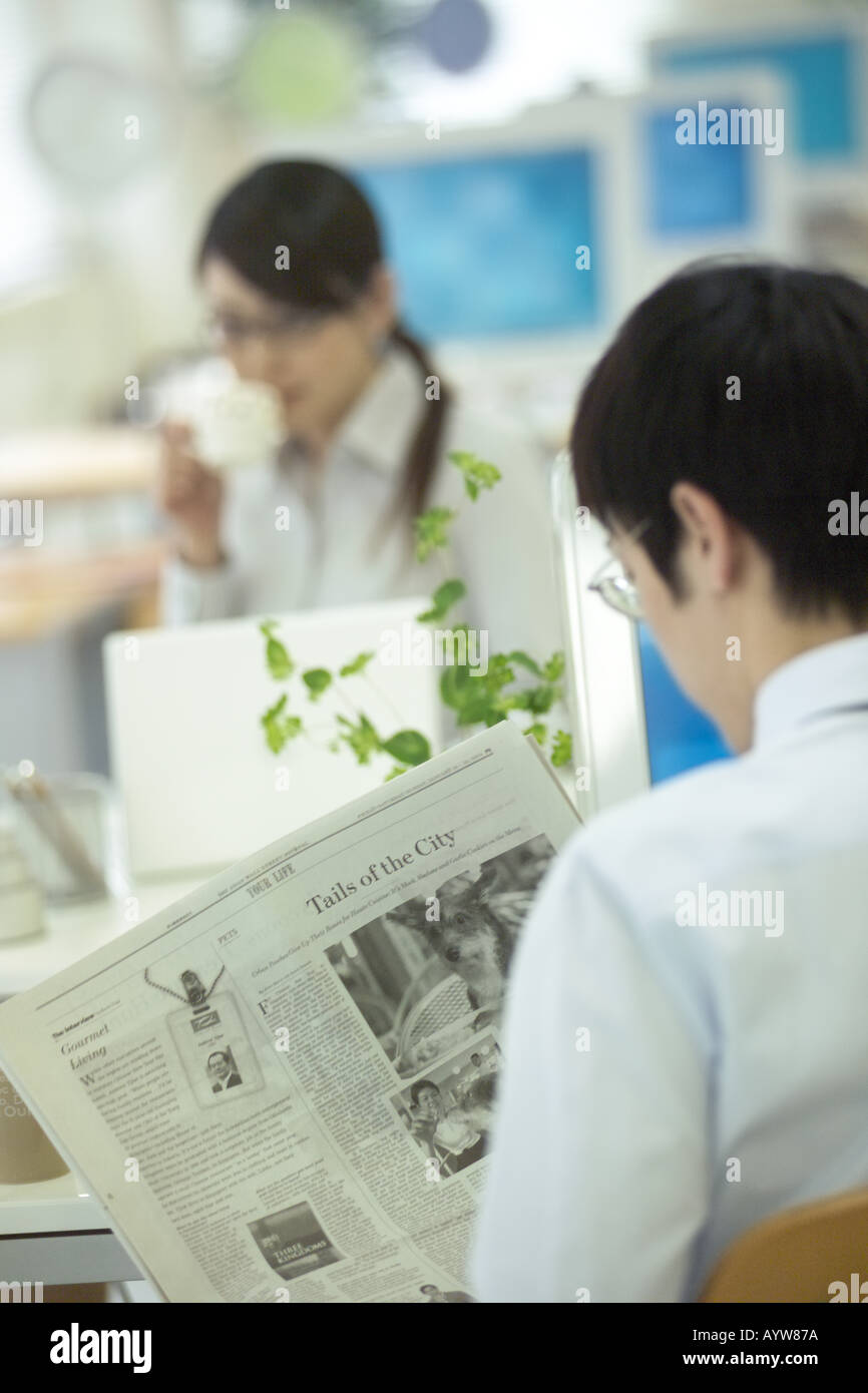 Office worker reading a newspaper in the office Stock Photo - Alamy
