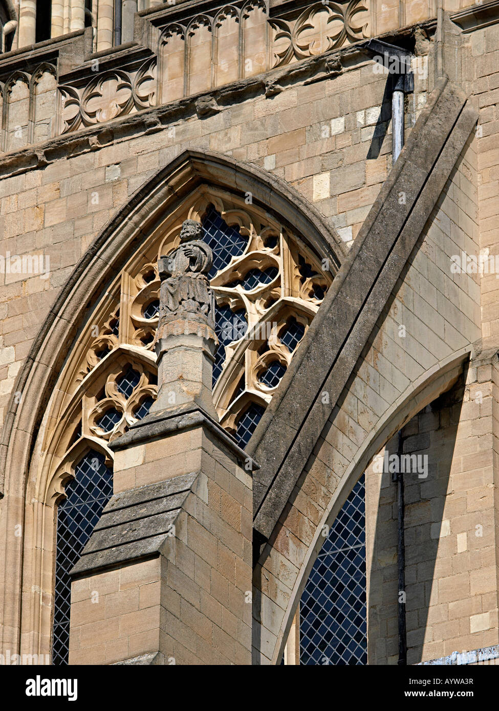 FLYING BUTTRESS AND STONE STATUE WITH STAINED GLASS WINDOW BEHIND ...