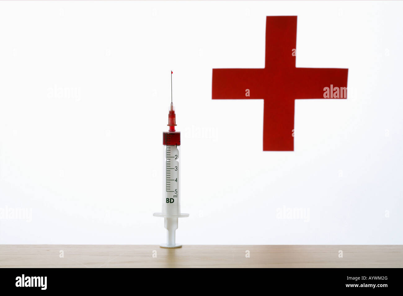 Syringe with red liquid and red cross Stock Photo - Alamy