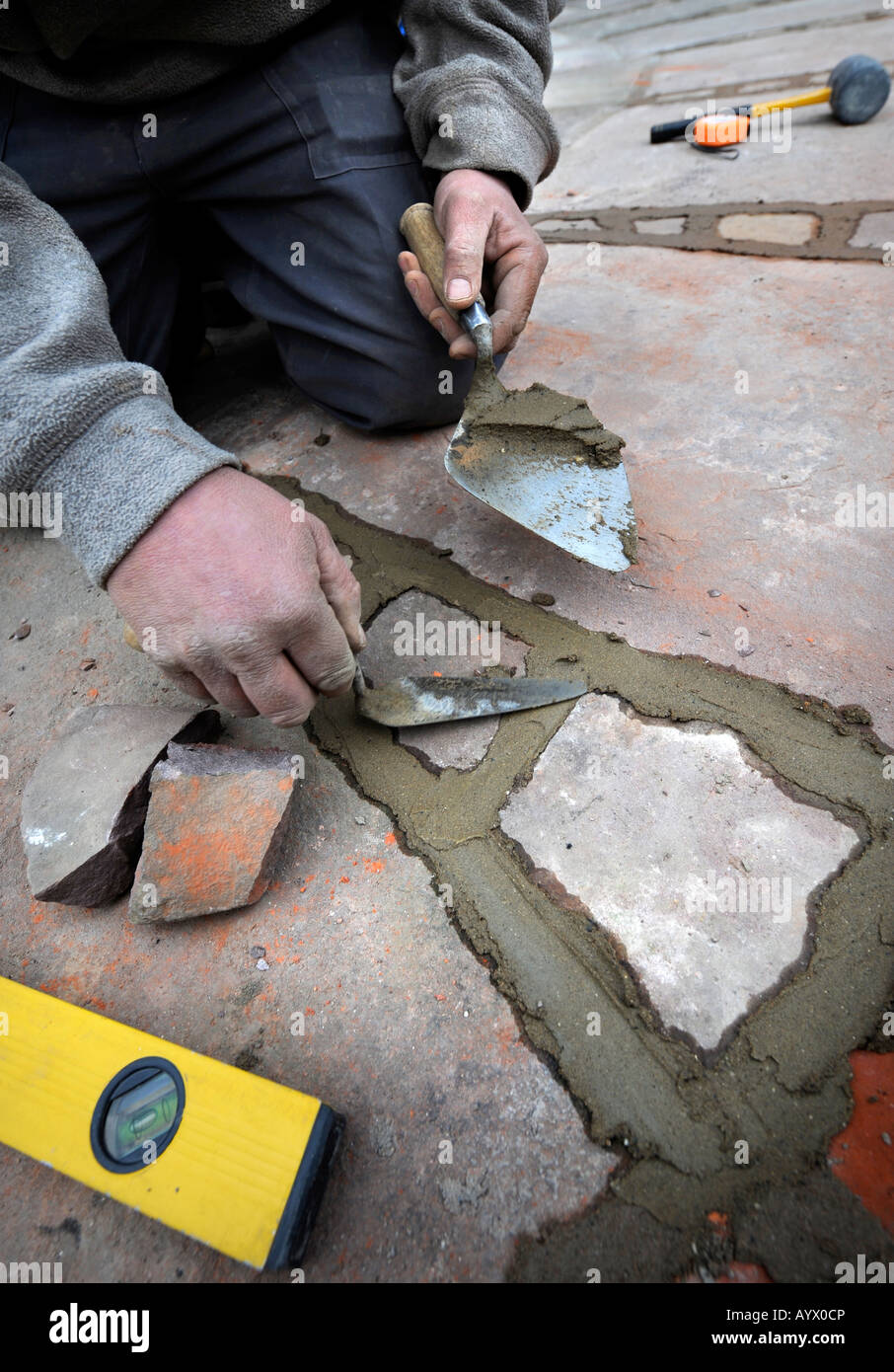 A BUILDER POINTING IN A PATIO LAID WITH NATURAL STONE SLABS UK Stock ...
