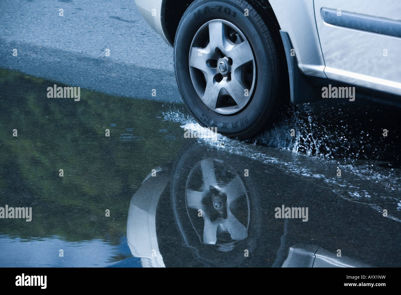 Detail of the tire of a car driving through a puddle Stock Photo - Alamy
