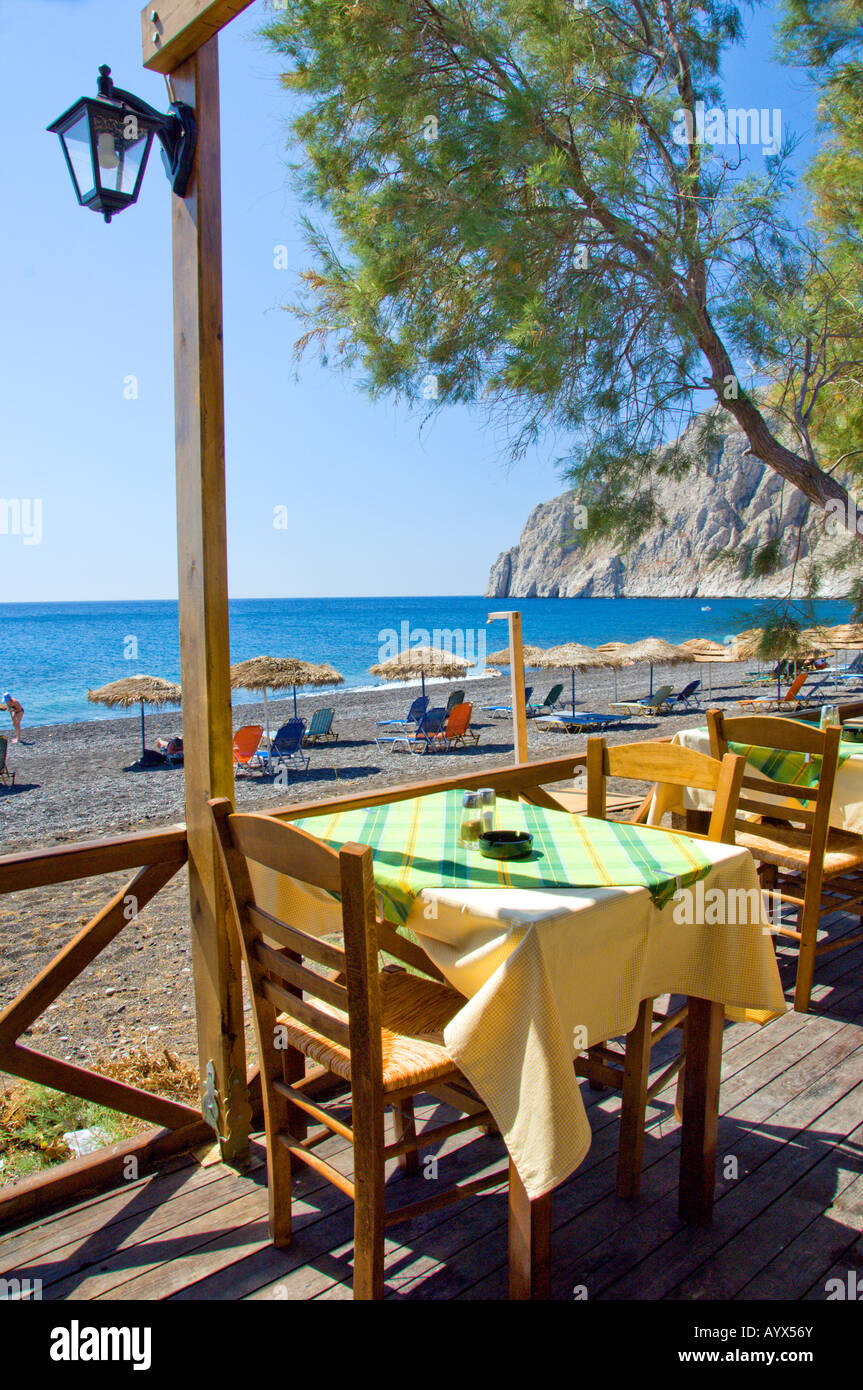 Restaurants and shops overlook the black sand beach in Kamari on the ...