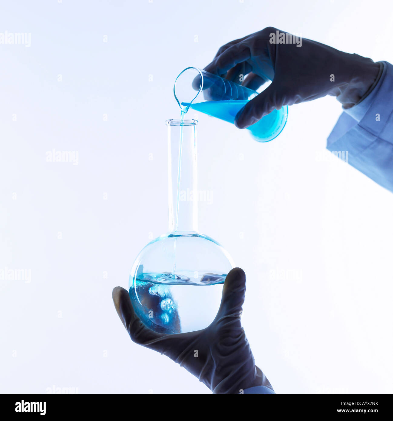 hand holding blue flask and cylinder Stock Photo - Alamy