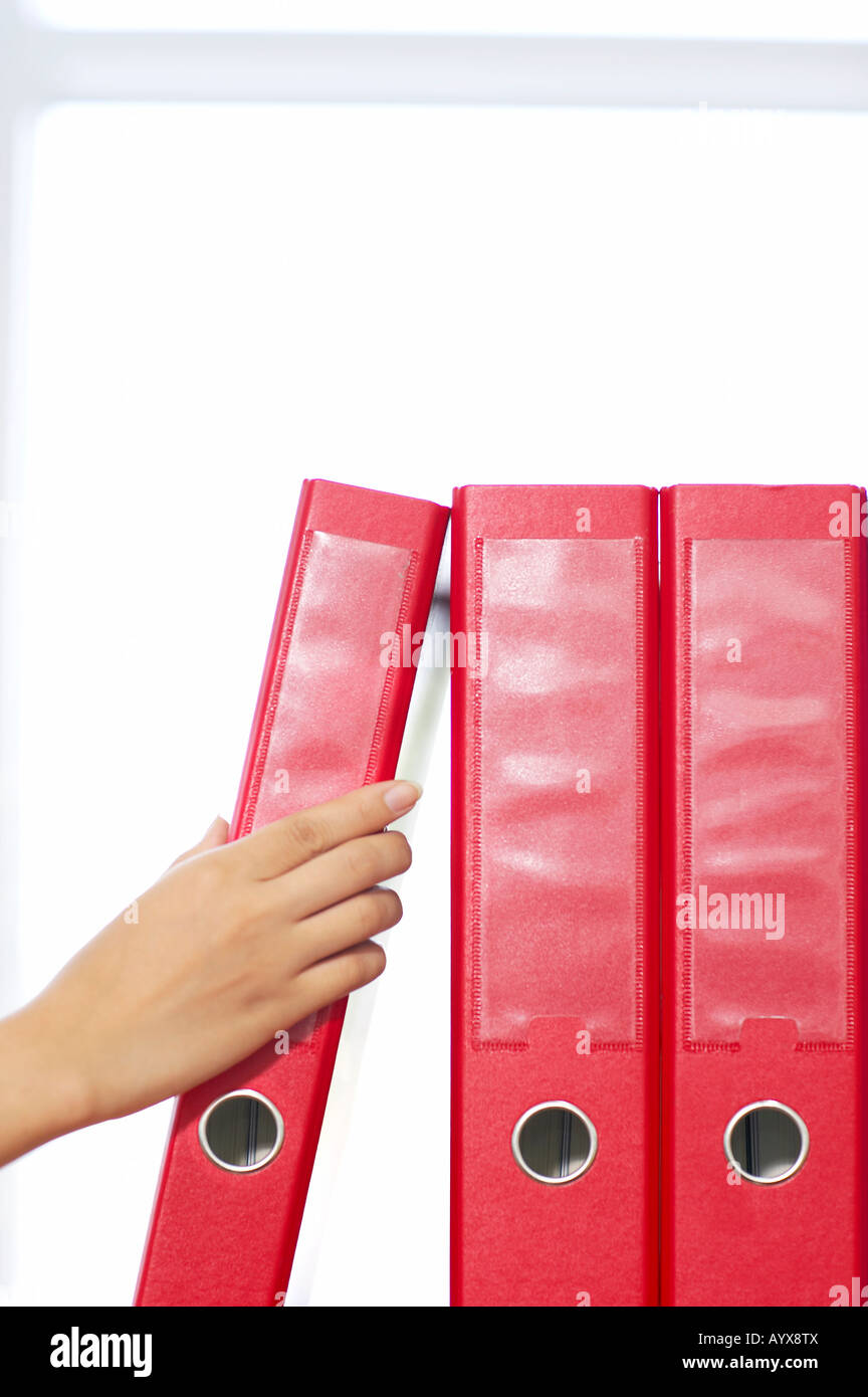 hand taking out red document file Stock Photo - Alamy
