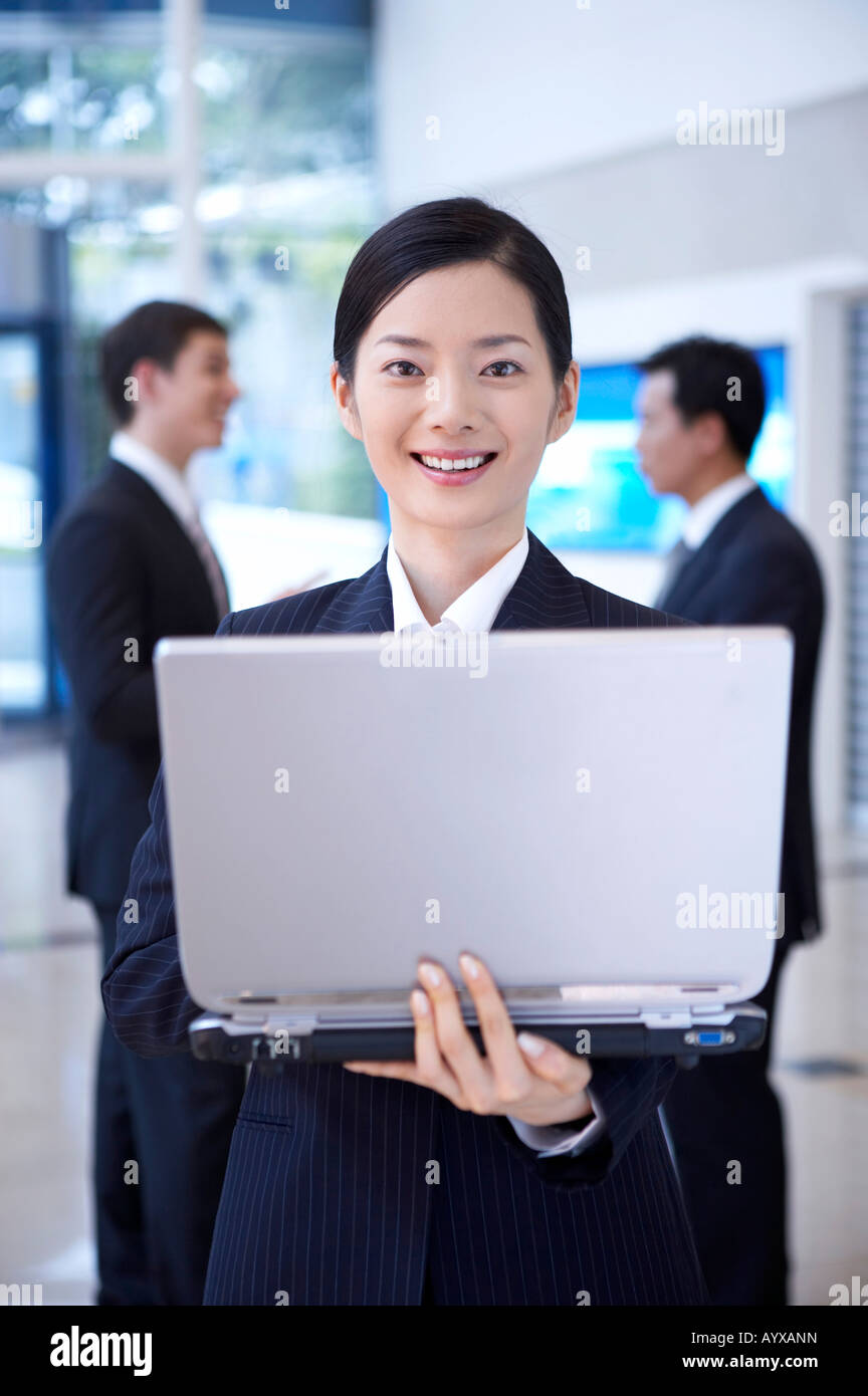 woman holding notebook and people behind her Stock Photo - Alamy
