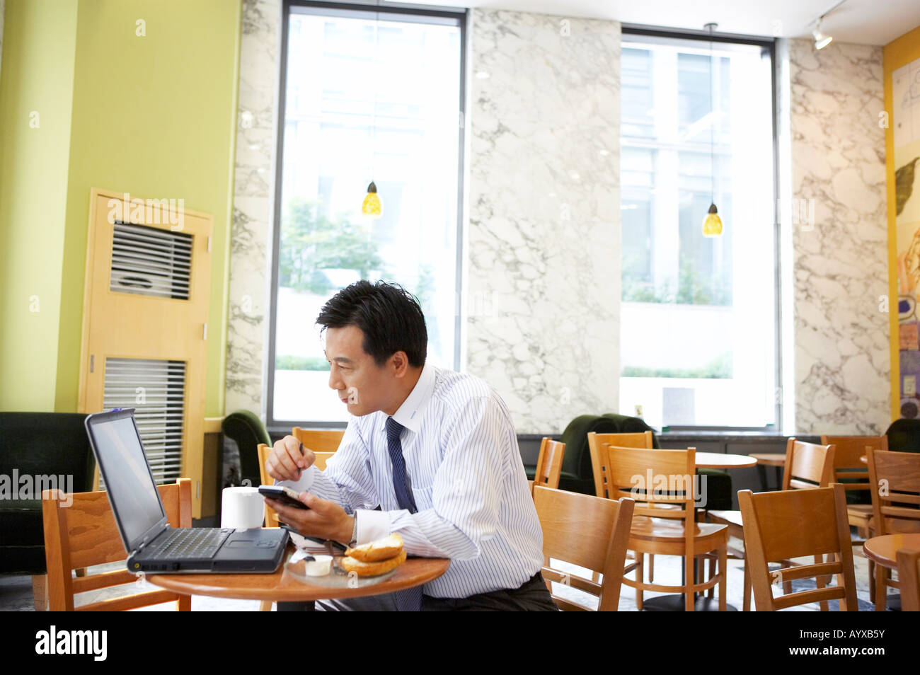 a man watching laptop computer with holding PDA on his a hand Stock ...