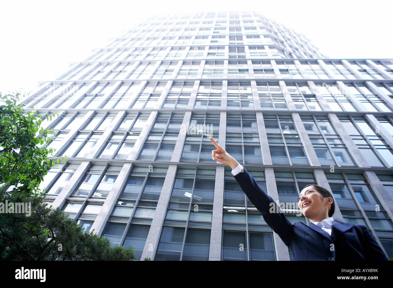 a woman pointing out direction in front of buildings with many windows ...