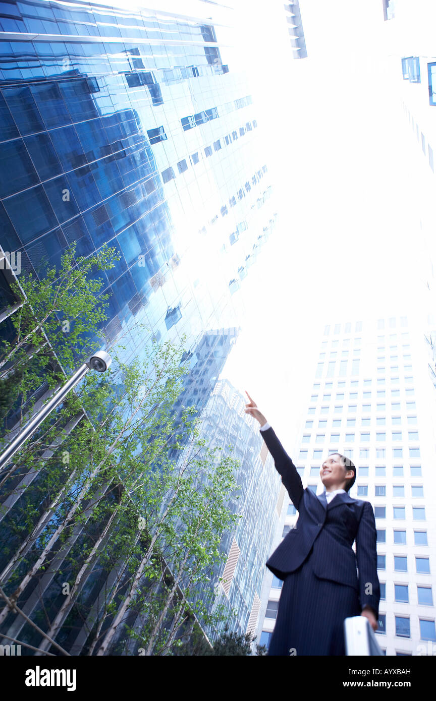 a woman pointing out direction in the middle of buildings Stock Photo ...