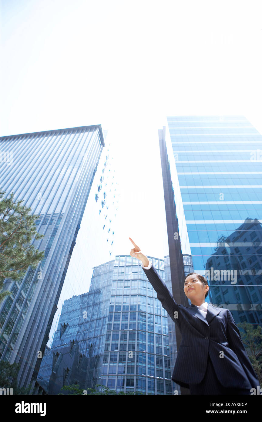 a woman pointing out direction by finger in the middle of buildings ...