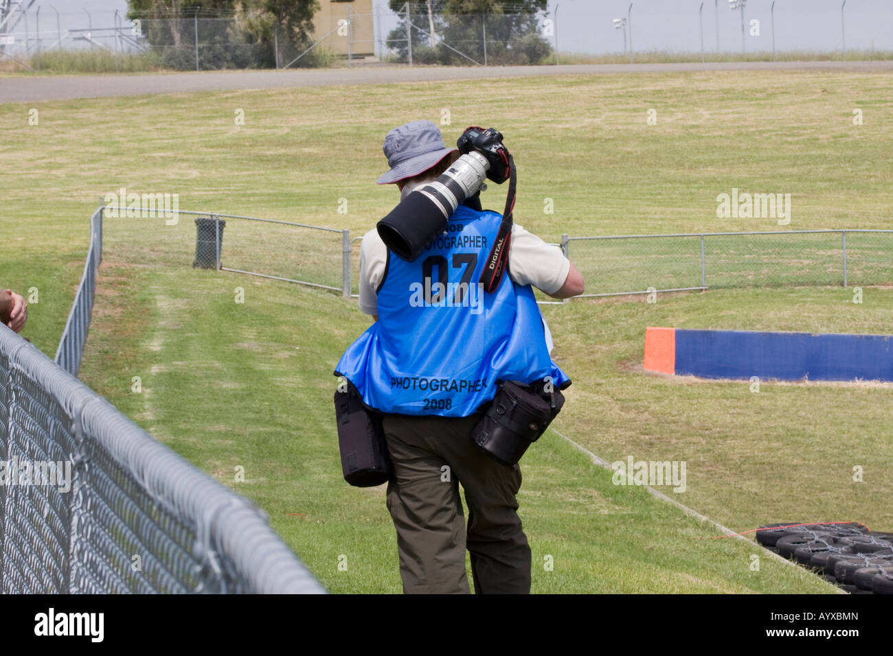 An accredited photographer carrying his camera and monopod walking to a ...