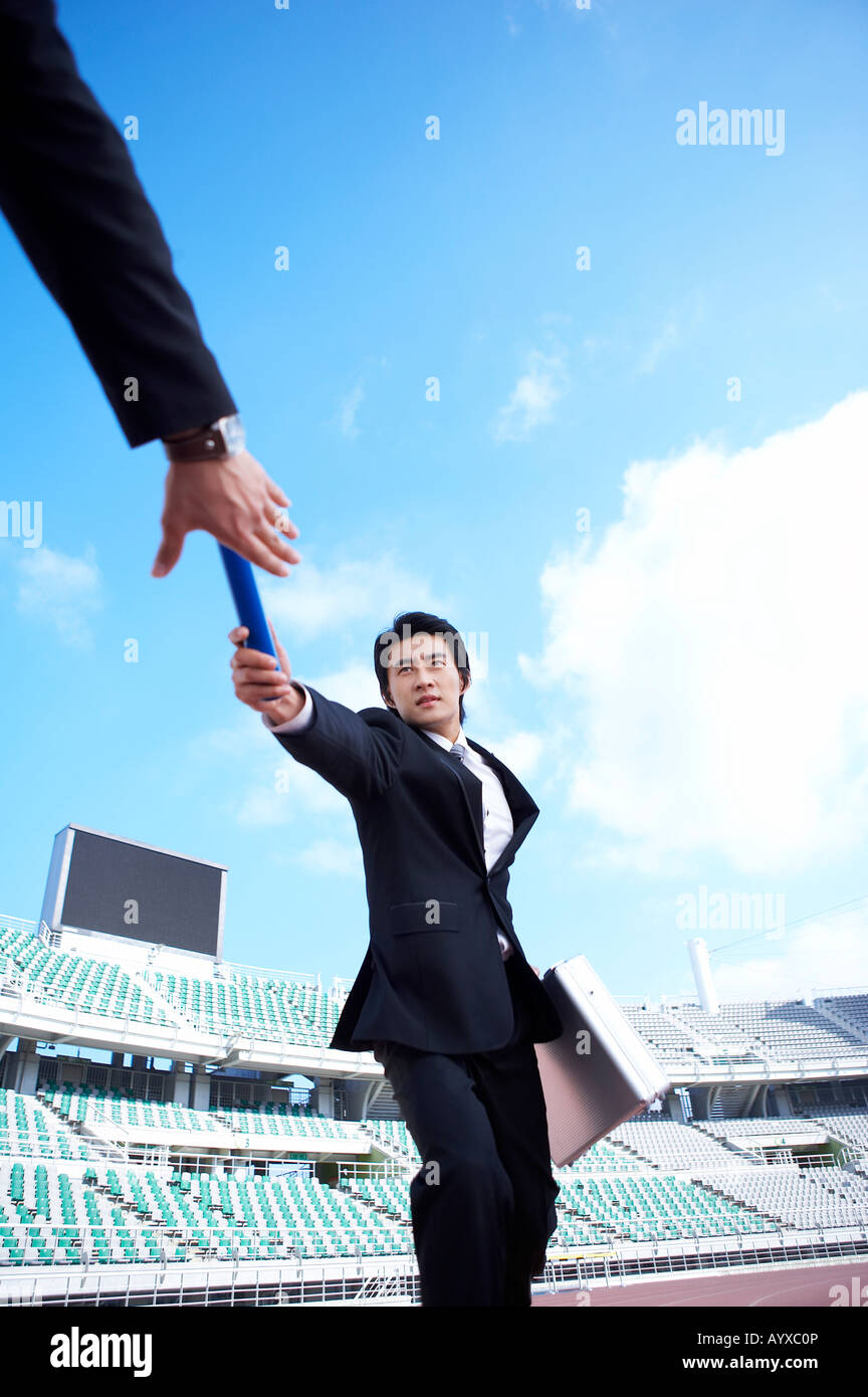 two men doing baton touch each other Stock Photo - Alamy