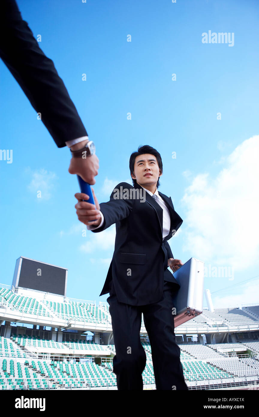 two men doing baton touch each other Stock Photo - Alamy