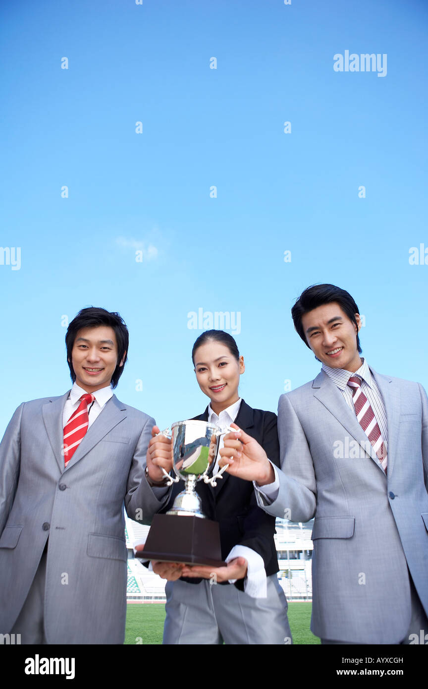 three person holding a trophy Stock Photo - Alamy