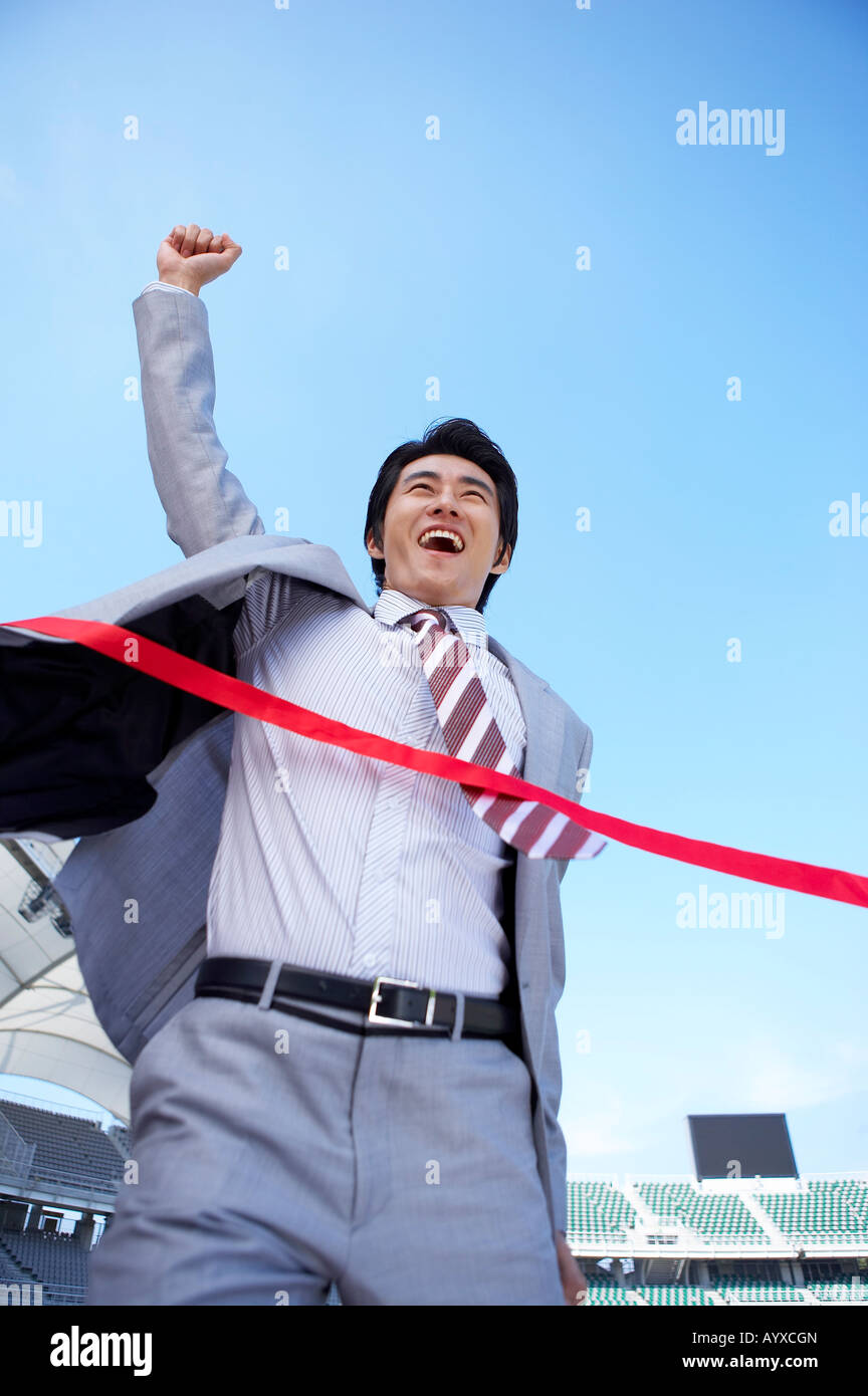 a man entering the finish line with raising her hand Stock Photo - Alamy