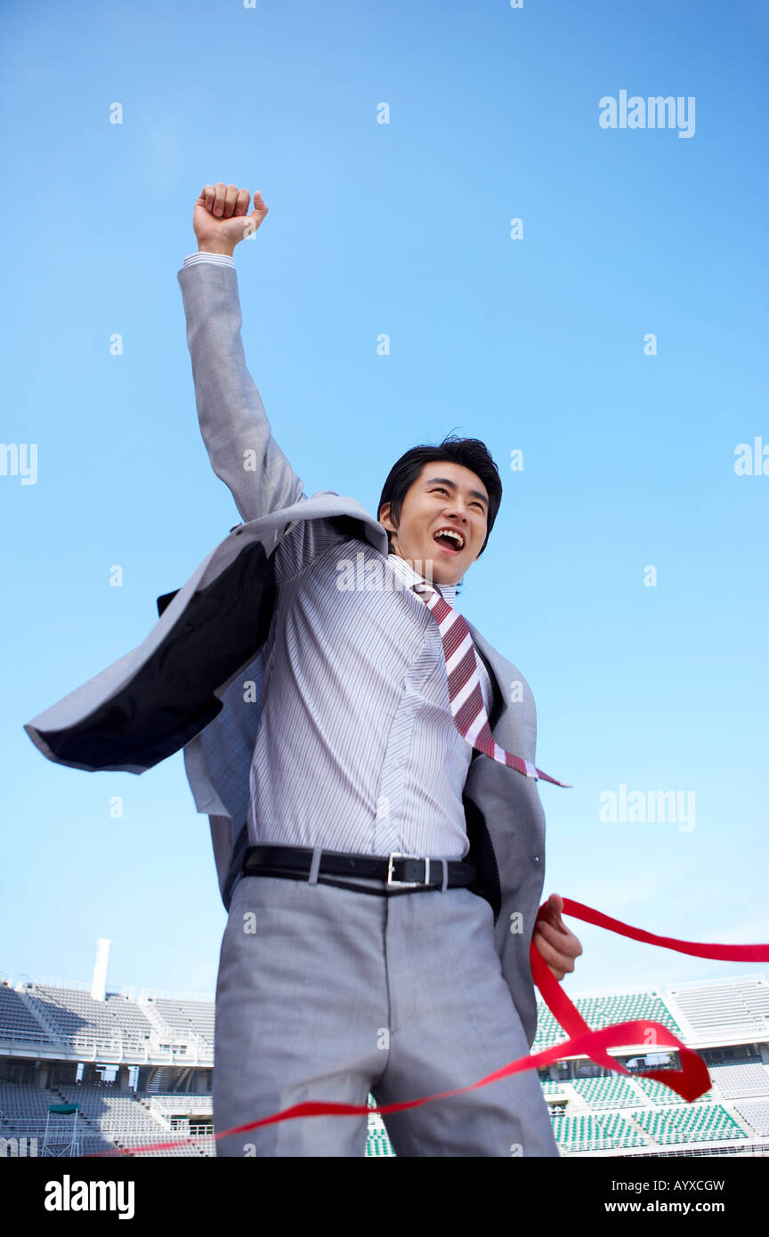 a man entering the finish line with raising her hand Stock Photo - Alamy