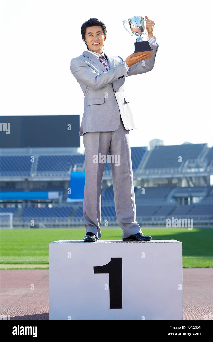 a man standing on the platform with a trophy Stock Photo - Alamy