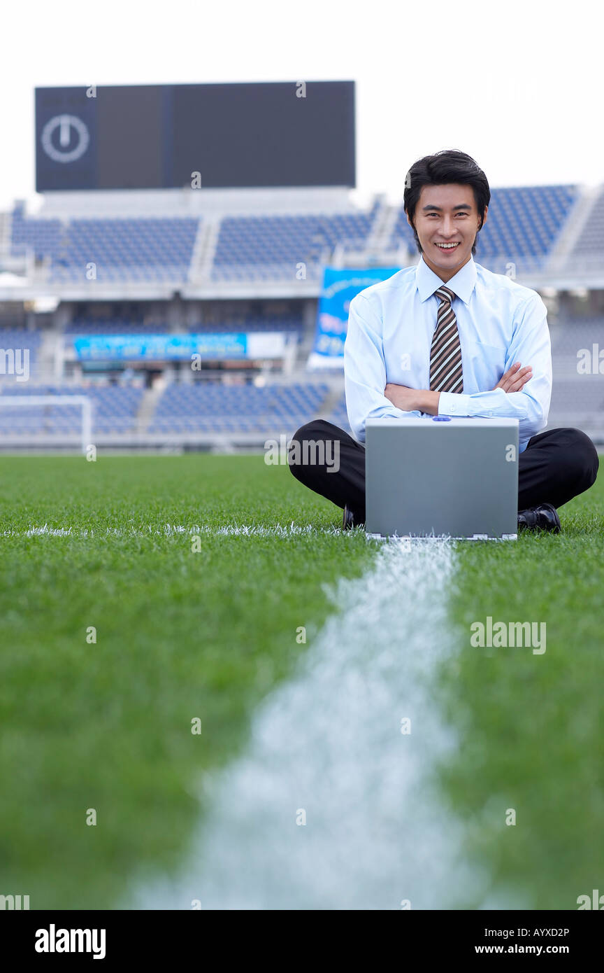a man seated by playground in an arena with laptop computer Stock Photo ...