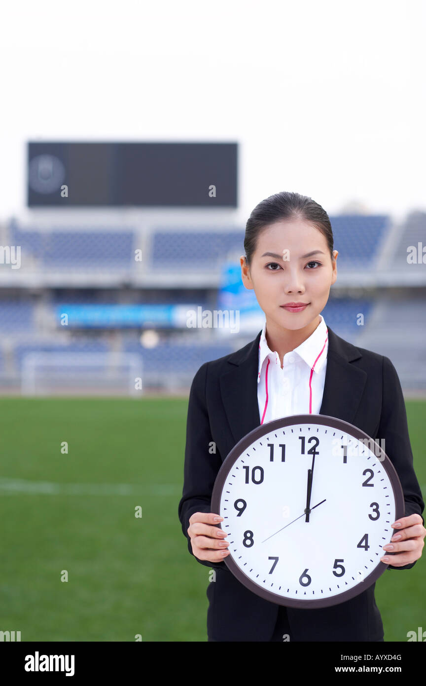 a woman holding a big clock Stock Photo - Alamy