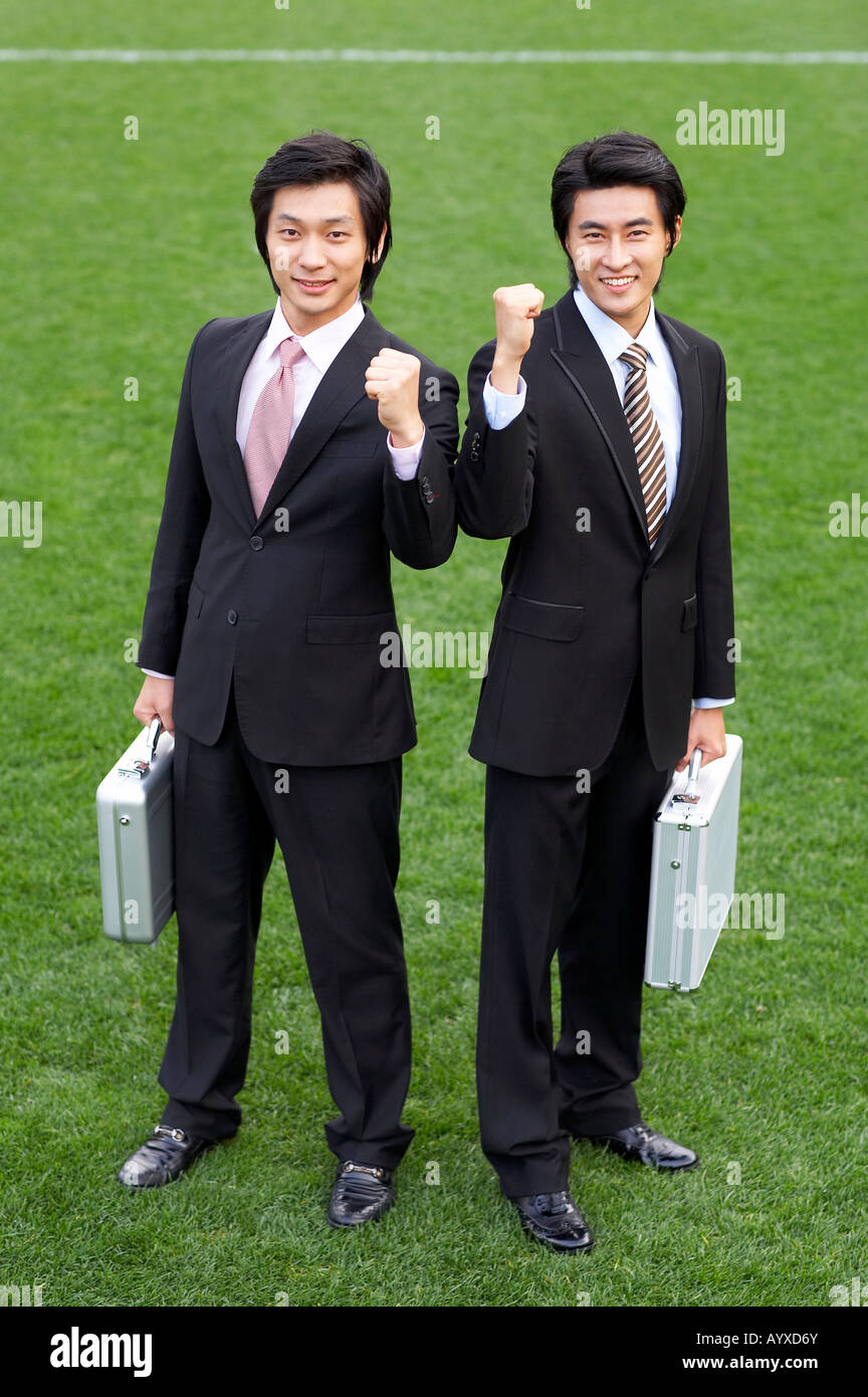 two men raising a fist in grass field Stock Photo - Alamy