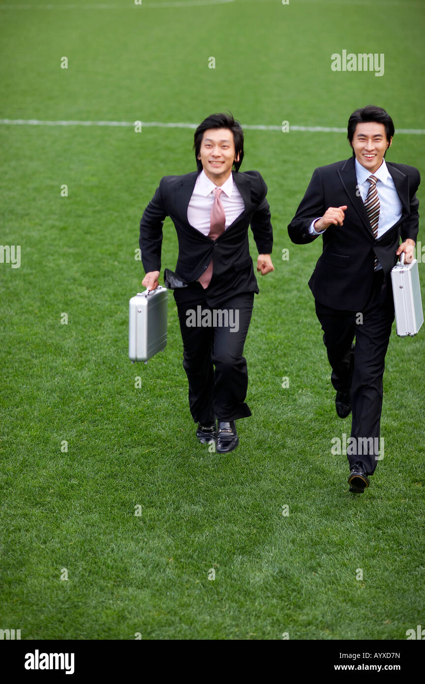 two men running on grass field with being smile Stock Photo - Alamy