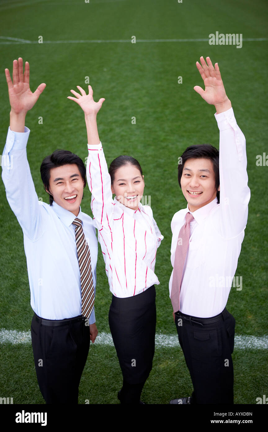 three smiling person raising their hands Stock Photo - Alamy