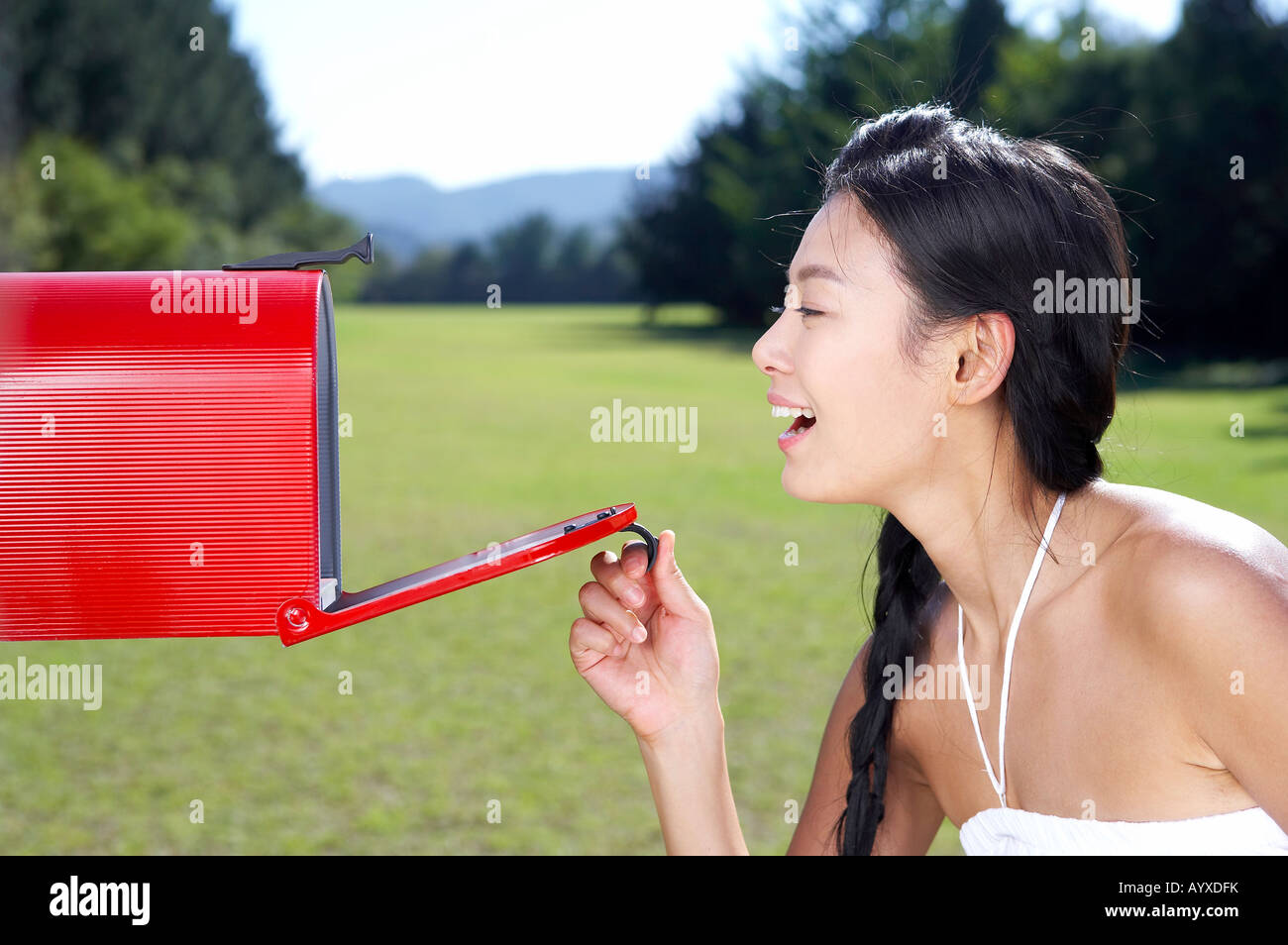 a smiling woman opening postbox Stock Photo - Alamy