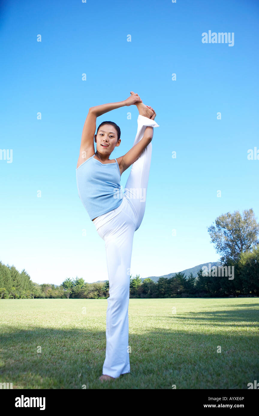 a woman excising on grass field Stock Photo - Alamy