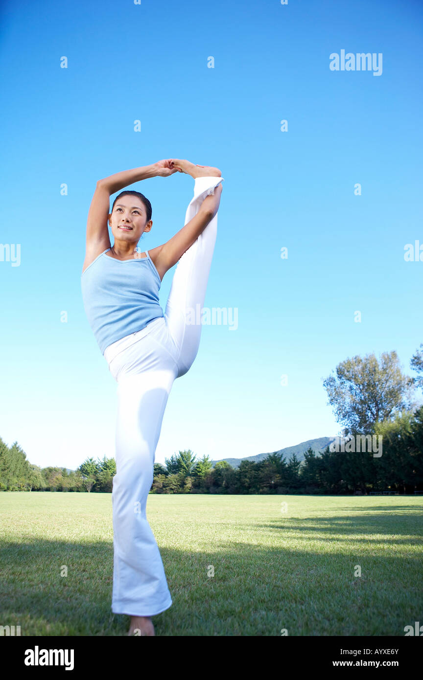 a woman excising on grass field Stock Photo - Alamy
