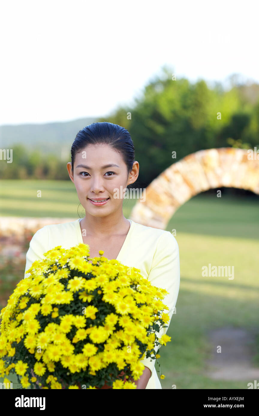 a woman holding yellow mum Stock Photo - Alamy