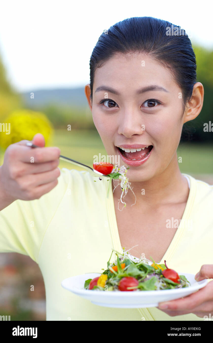 a woman is about to eat salad by a folk Stock Photo - Alamy
