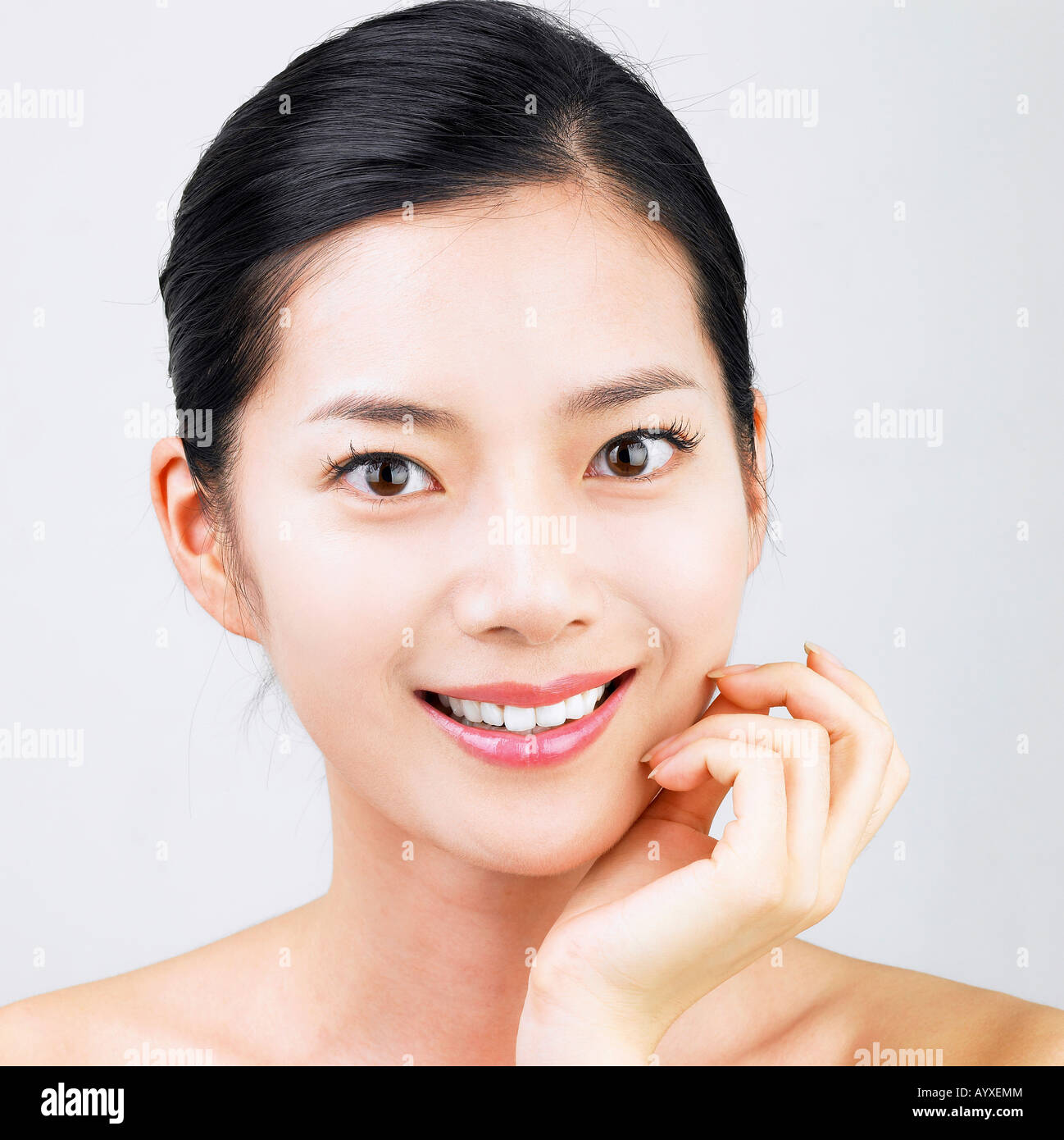 a woman's face smiling with put with a hand slightly Stock Photo - Alamy