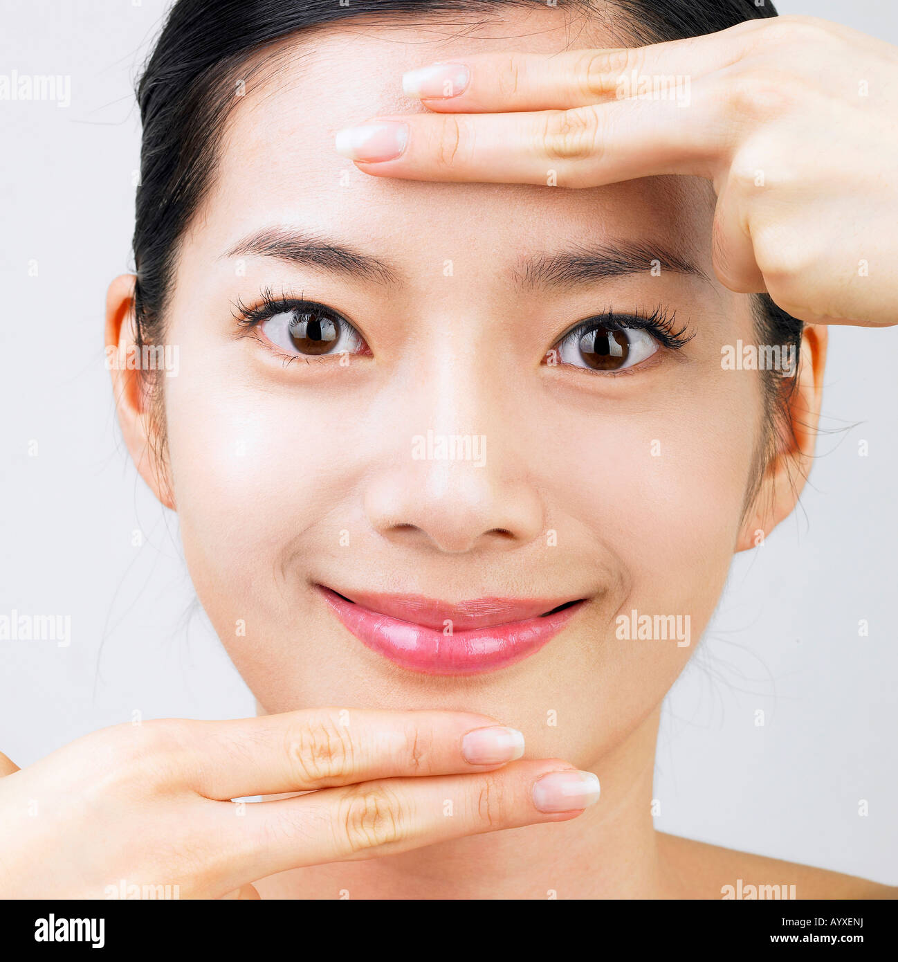 a woman's face smiling with put with finger on forehead and chin Stock ...