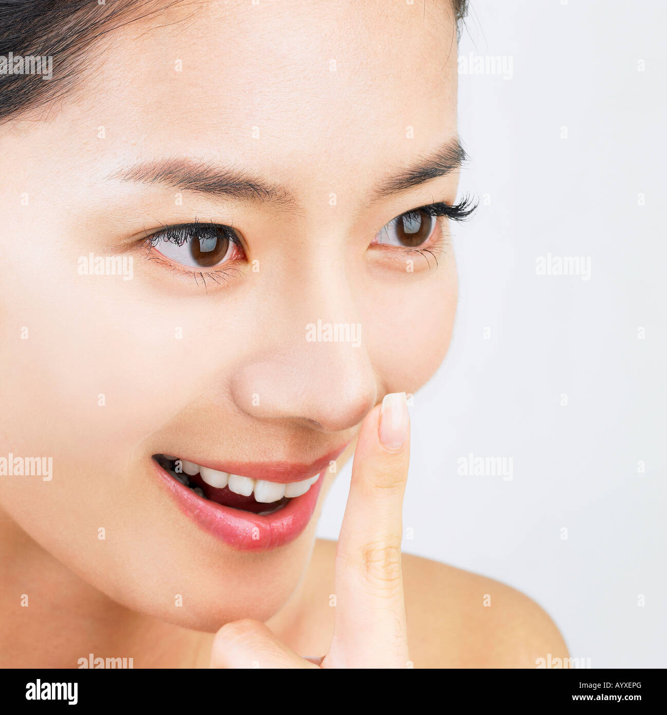 a woman's face smiling put finger on the tip of her nose Stock Photo ...