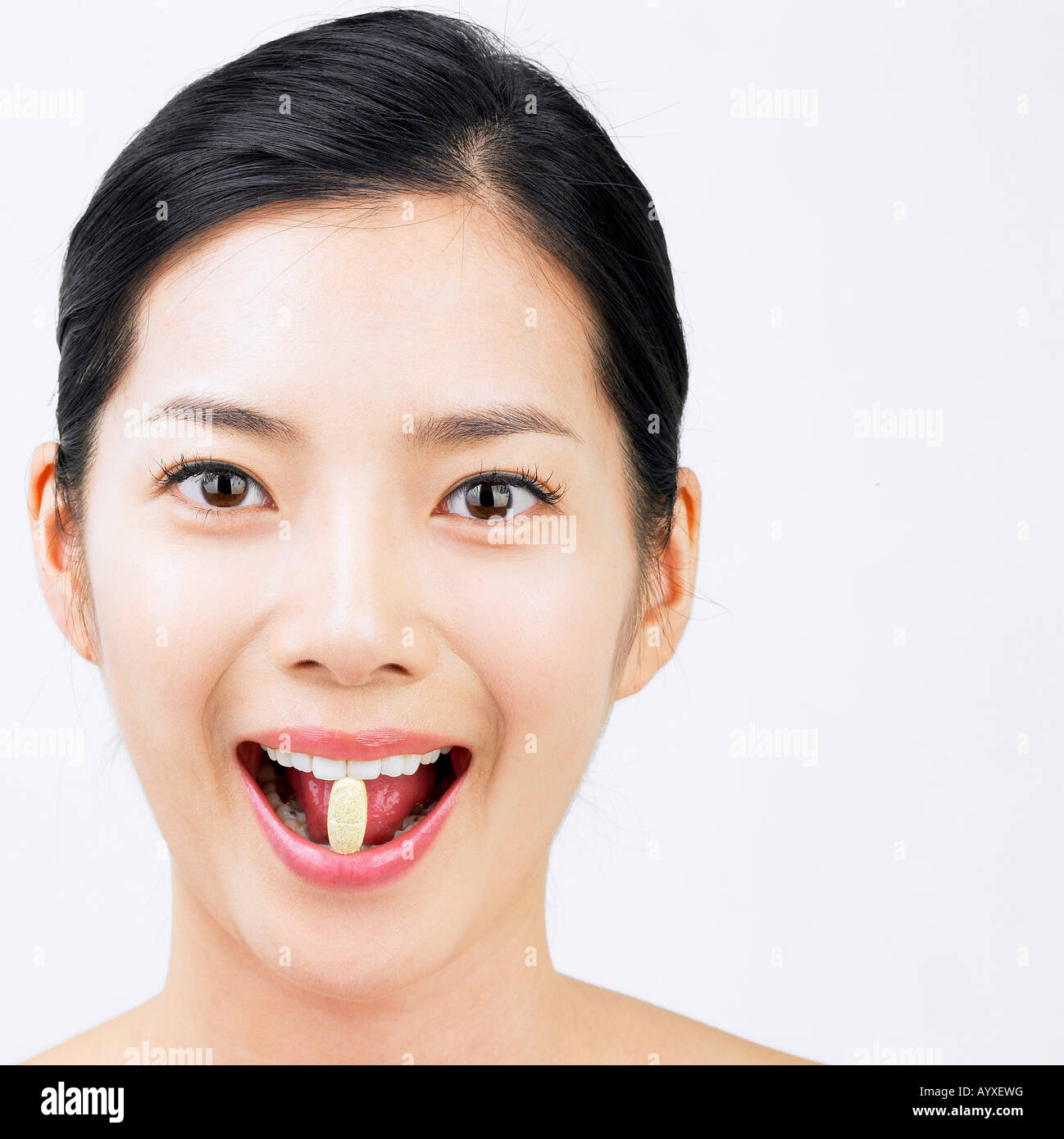 a woman's face biting a tablet Stock Photo - Alamy