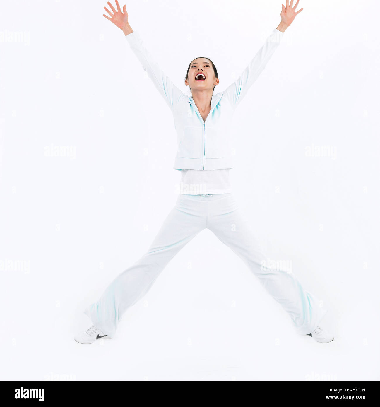 a woman in sportswear jumping with rasing her hand over her head Stock ...