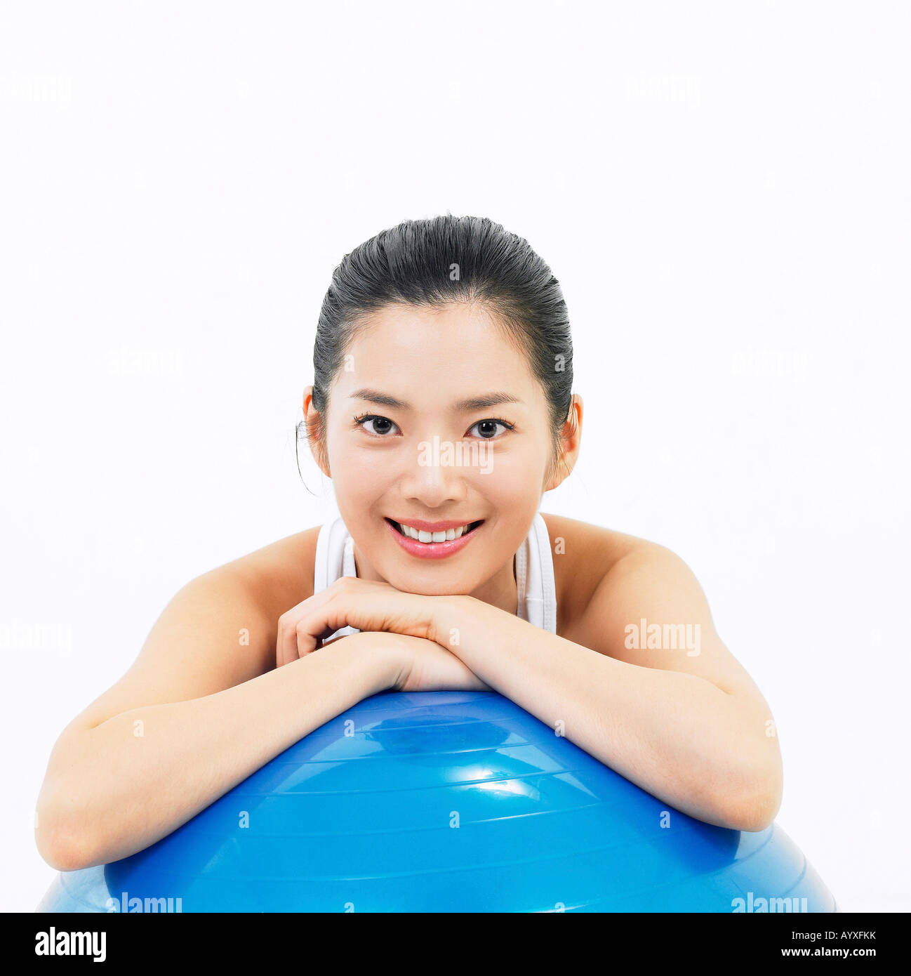 a woman resting her chin on her hand on a blue ball Stock Photo - Alamy