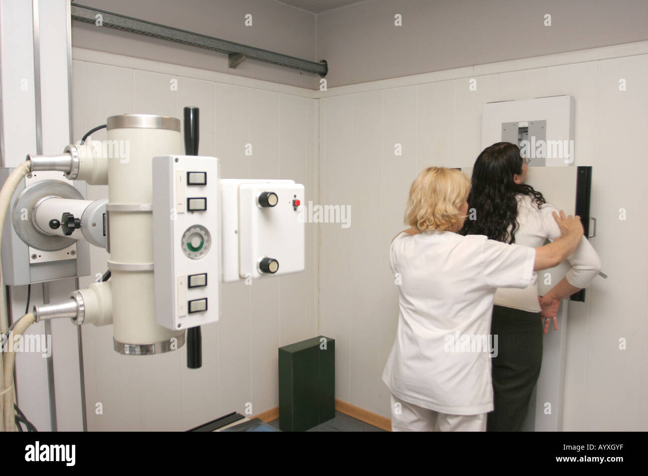 Radiographer doctor puting a woman patient in position to take an X Ray ...
